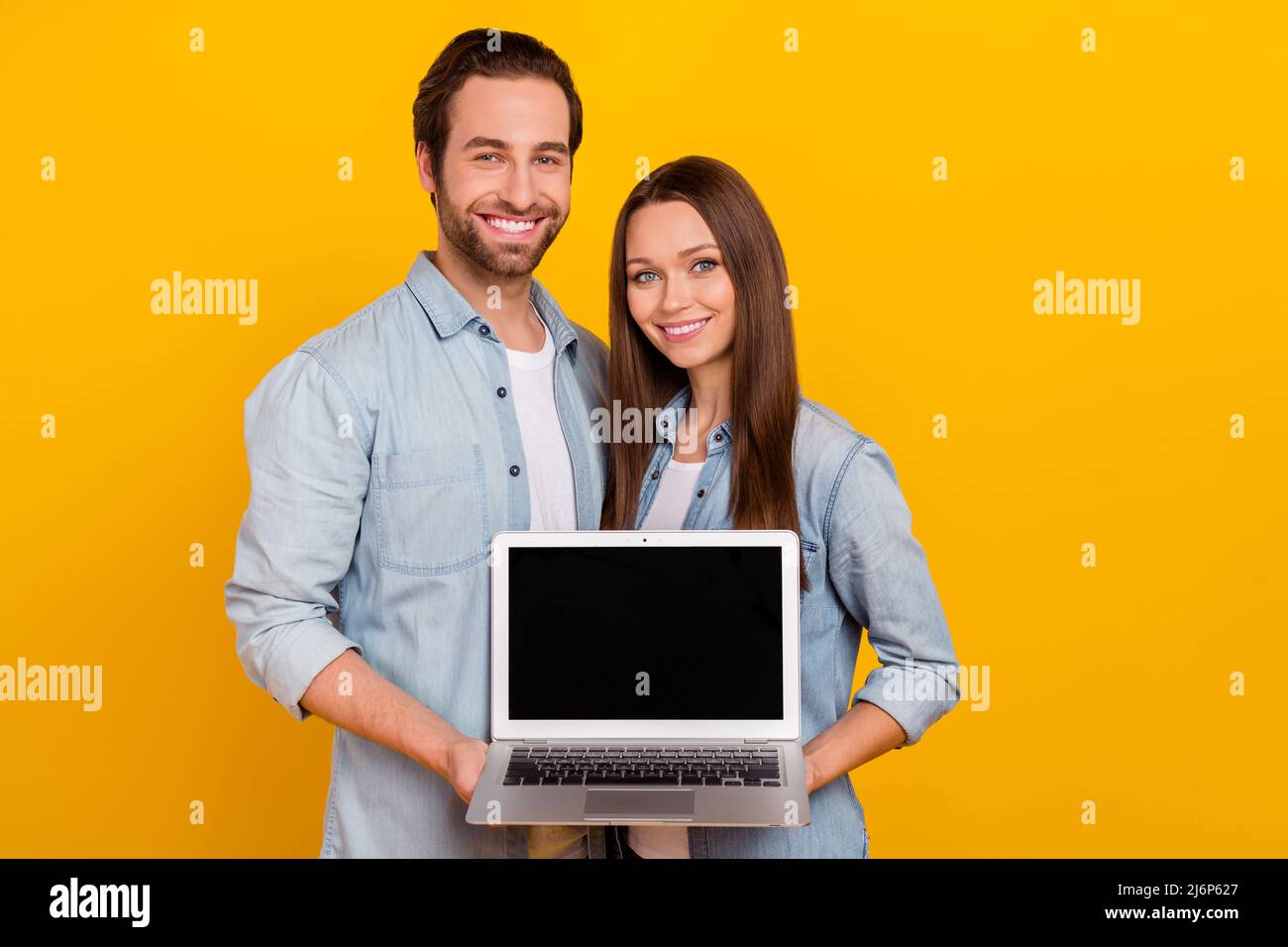 Portrait of handsome beautiful cheerful couple holding laptop copy ...