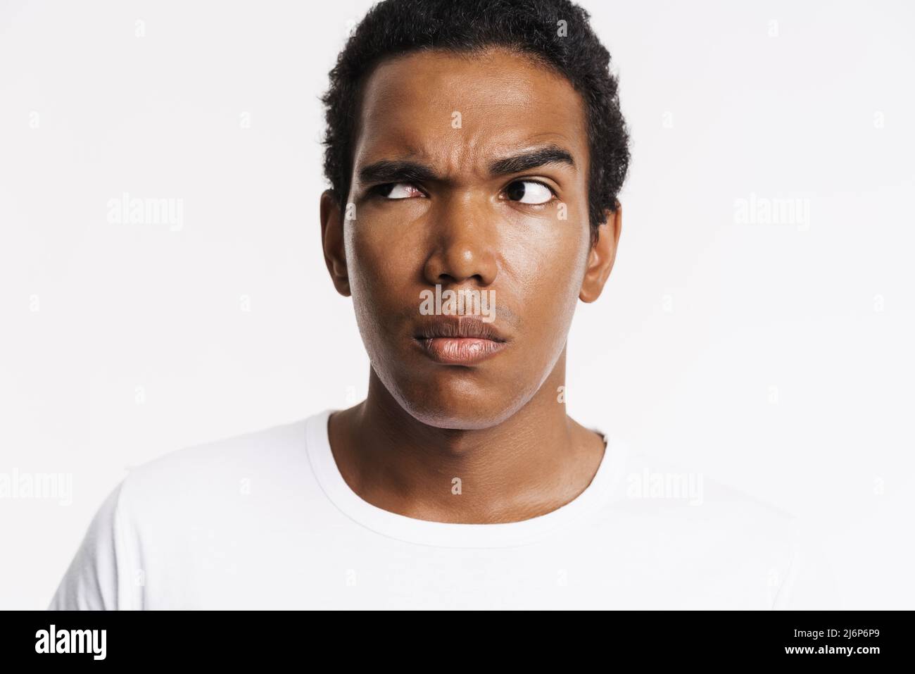 Young black man dressed t-shirt looking aside and frowning isolated ...
