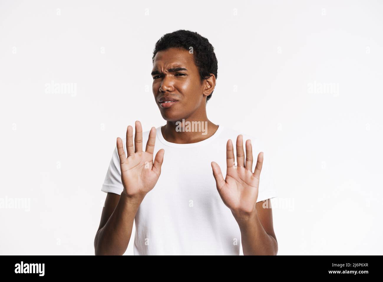 Young black man frowning while making stop gesture isolated over white ...