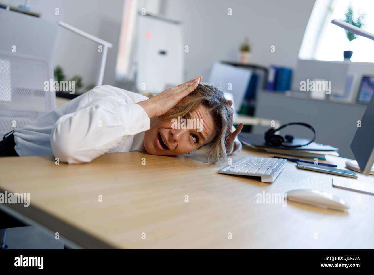 Scared businesswoman shielding her head during the attack on the office ...