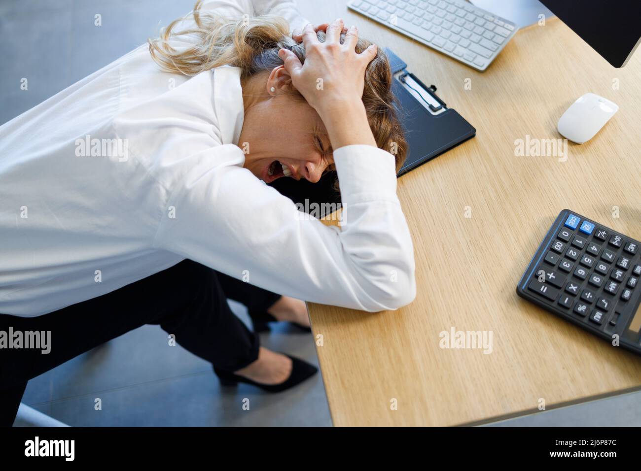 Depressed office worker holding her head and screaming, problems at ...