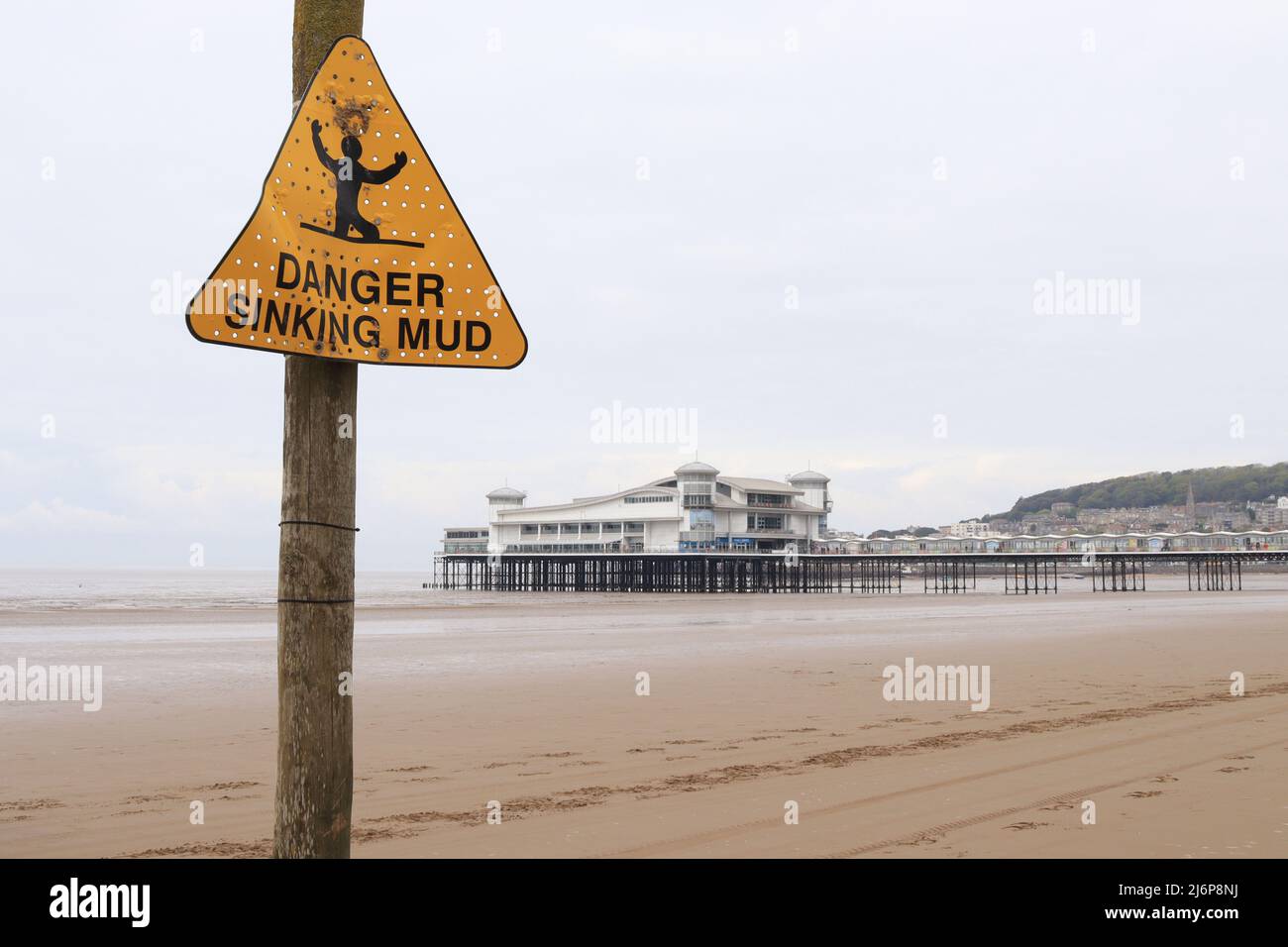 'DANGER SINKING MUD' sign with Weston-super-Mare's Grand Pier in the ...