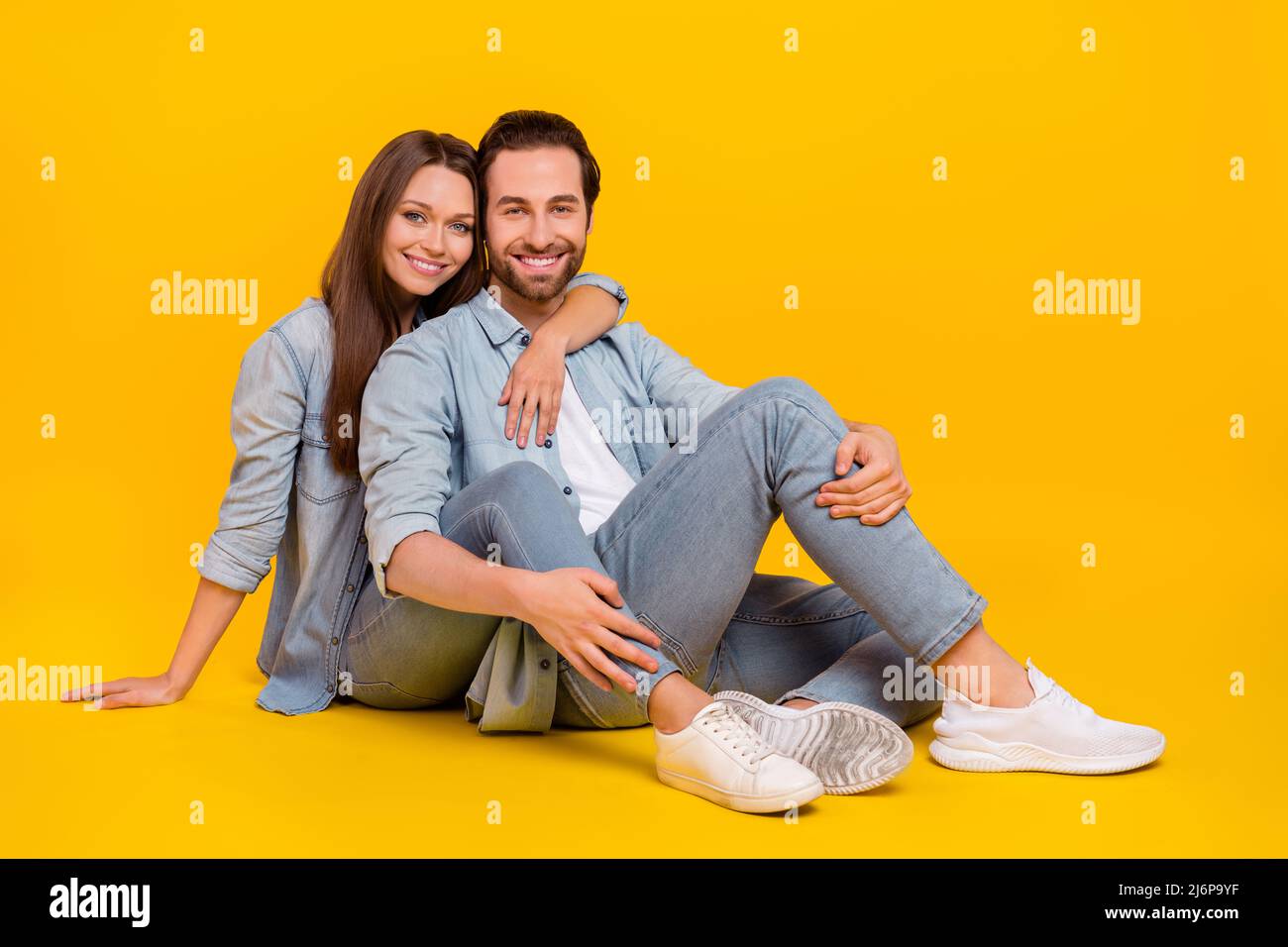 Portrait of two attractive cheerful sweet people sitting hugging ...