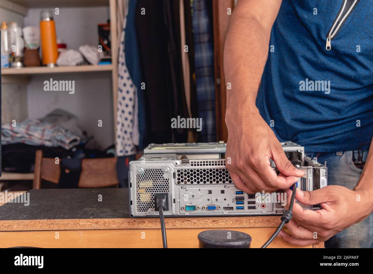 Unrecognizable young brunette man in a bedroom standing installing ...