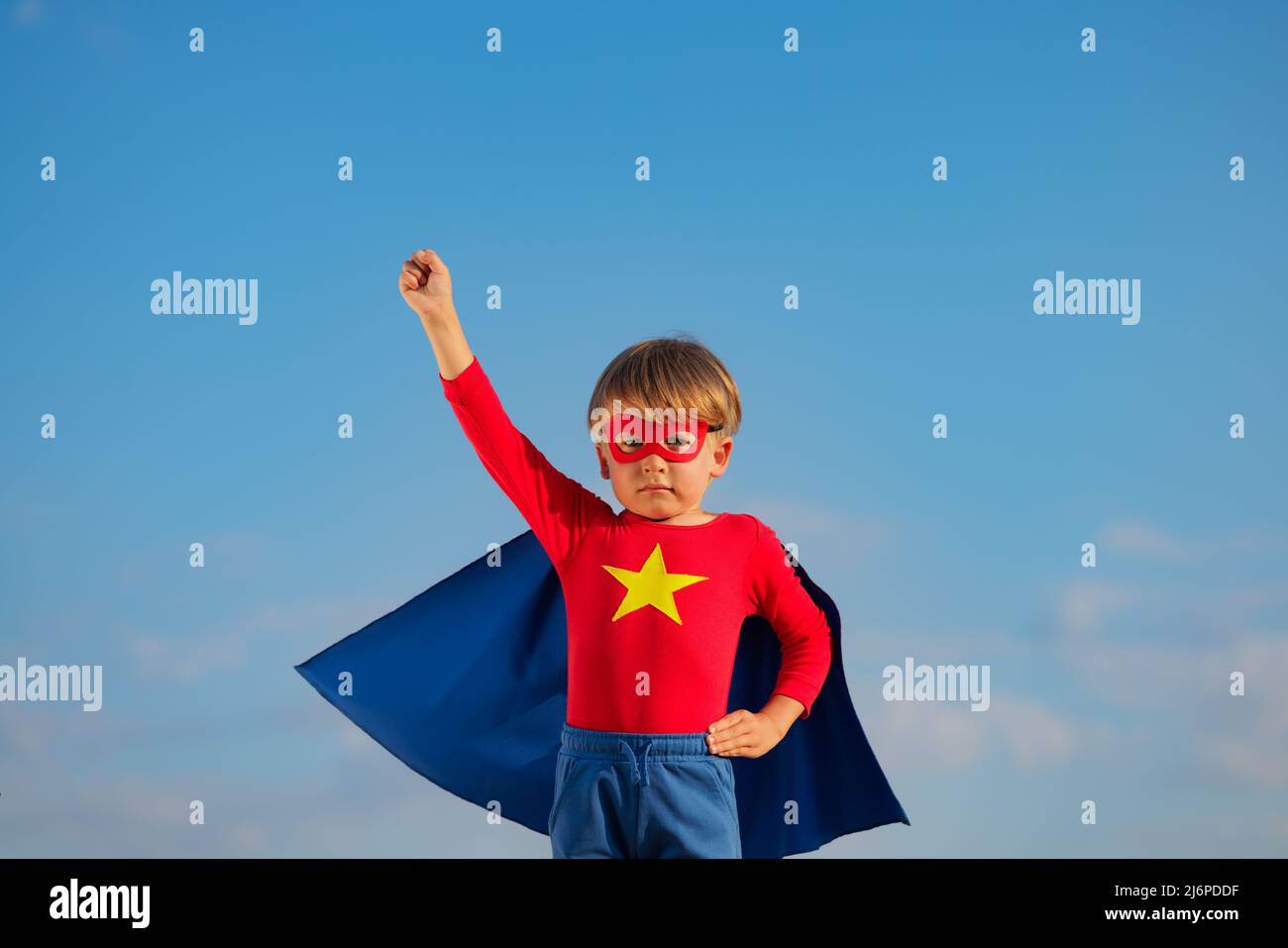 Superhero child playing outdoor. Super hero kid against blue summer sky ...