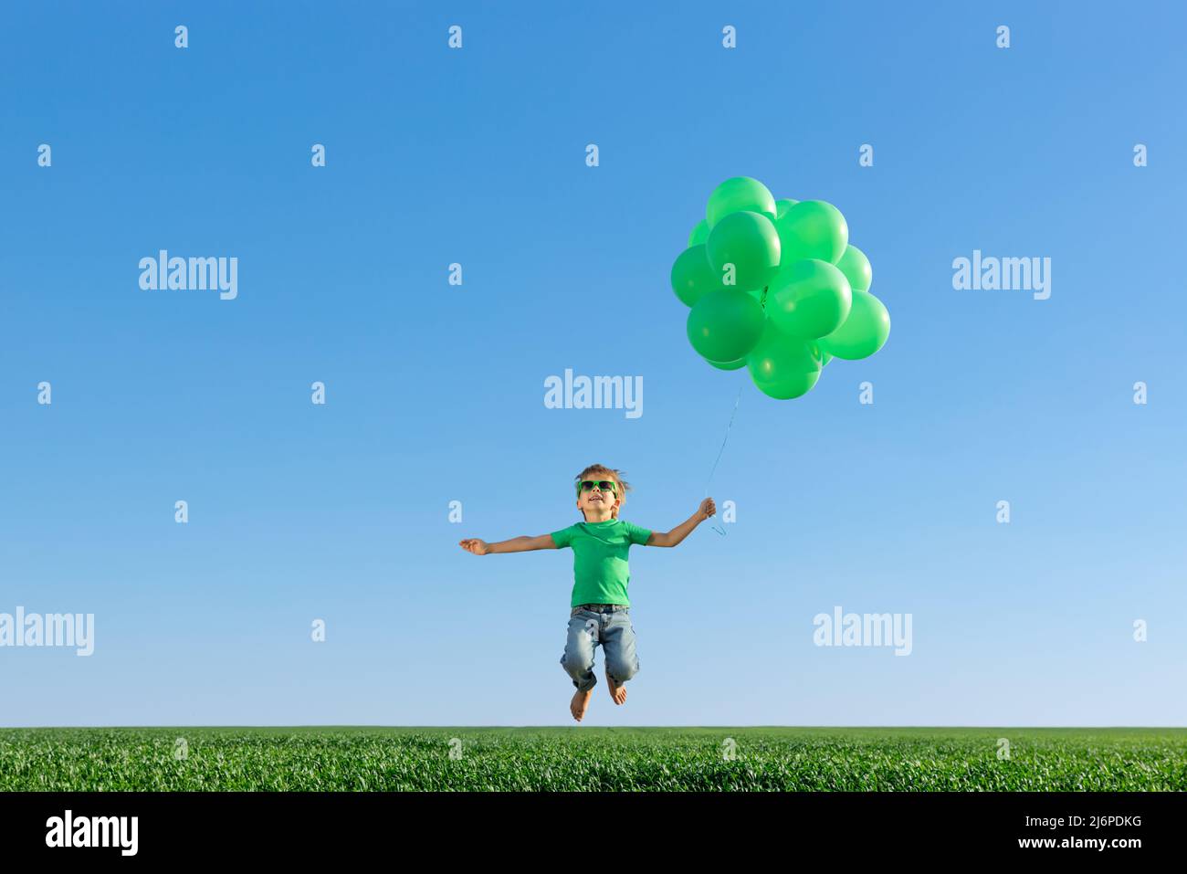 Happy child playing with bright multicolor balloons outdoor. Kid having ...