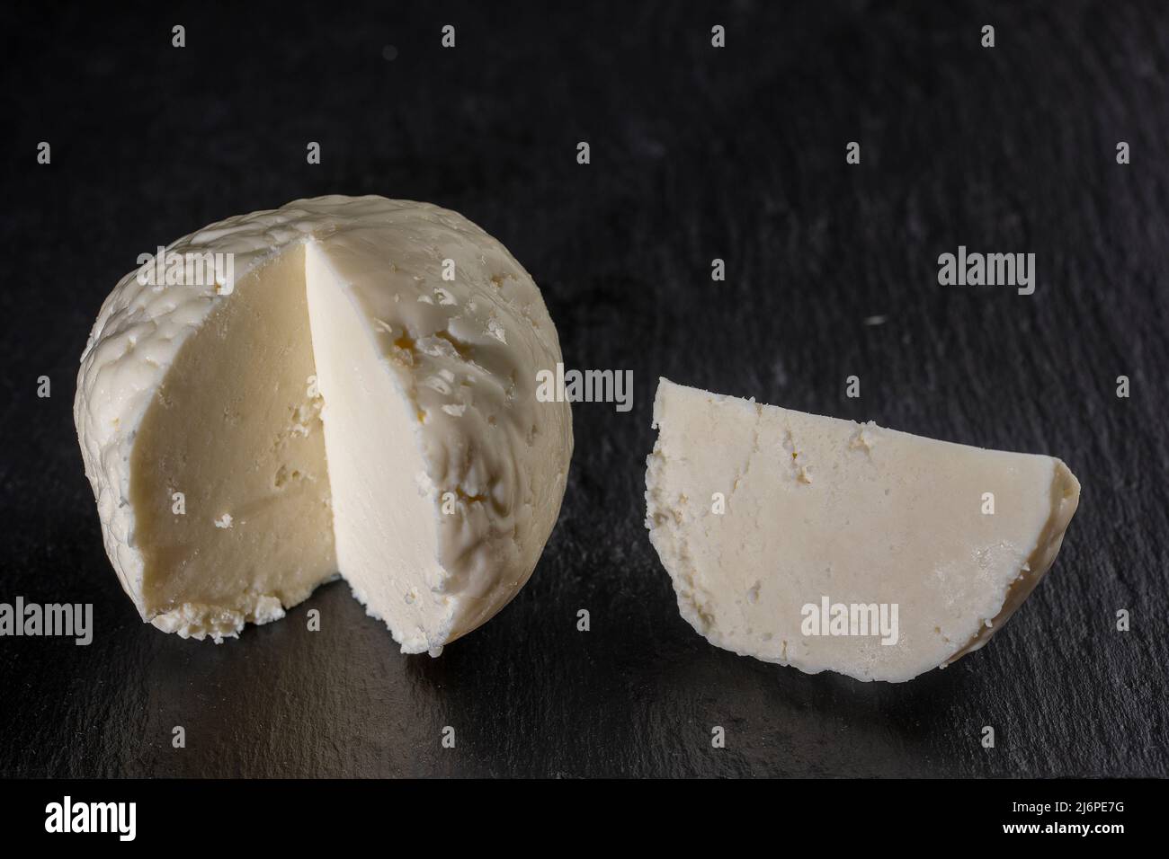 Homemade soft white cheese on black slate background, close up. Home ...