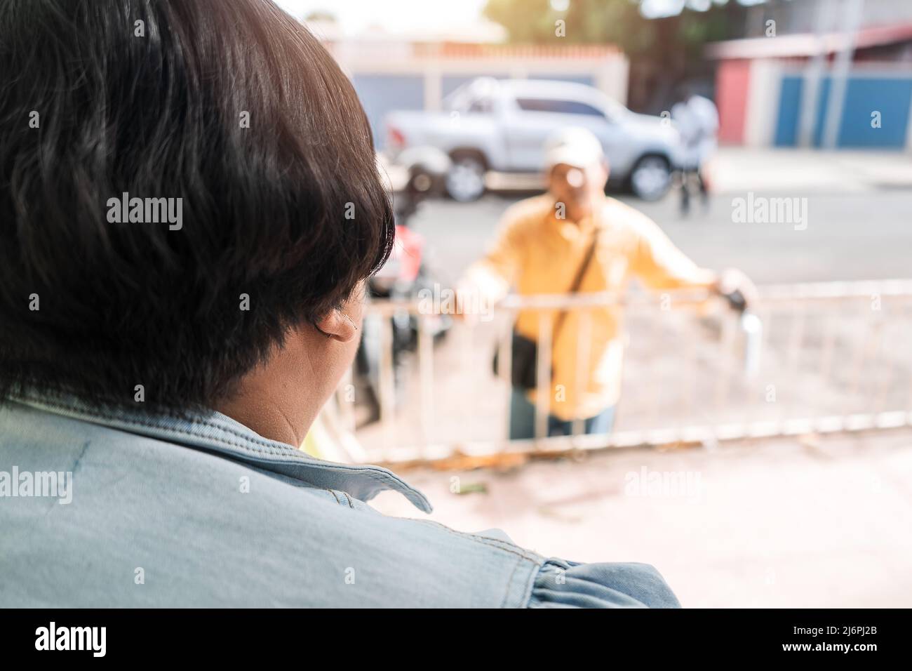 Latin woman talking and gossiping with a man from afar Stock Photo - Alamy