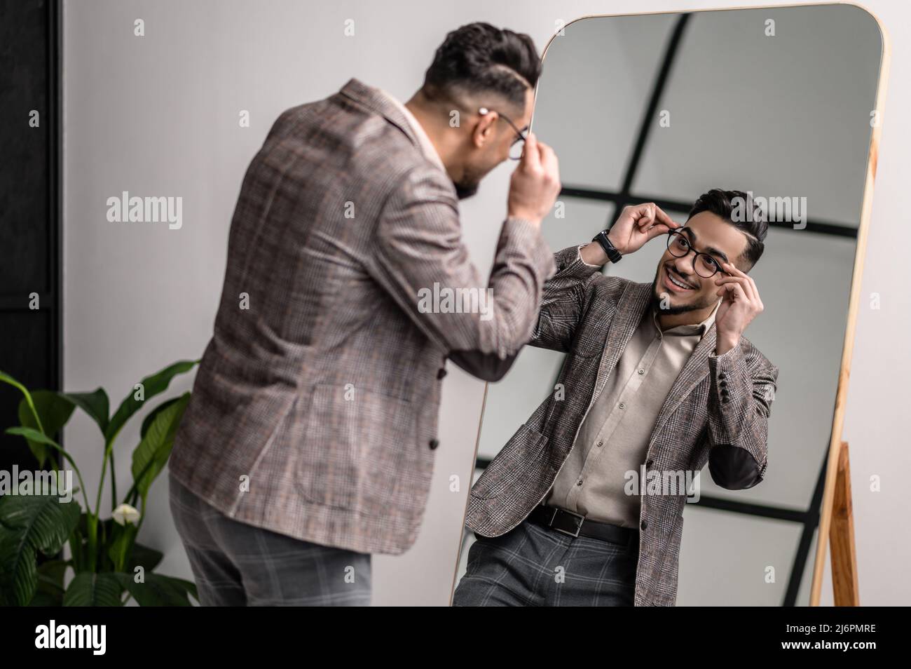 A good-looking young elegant man at the mirror Stock Photo - Alamy