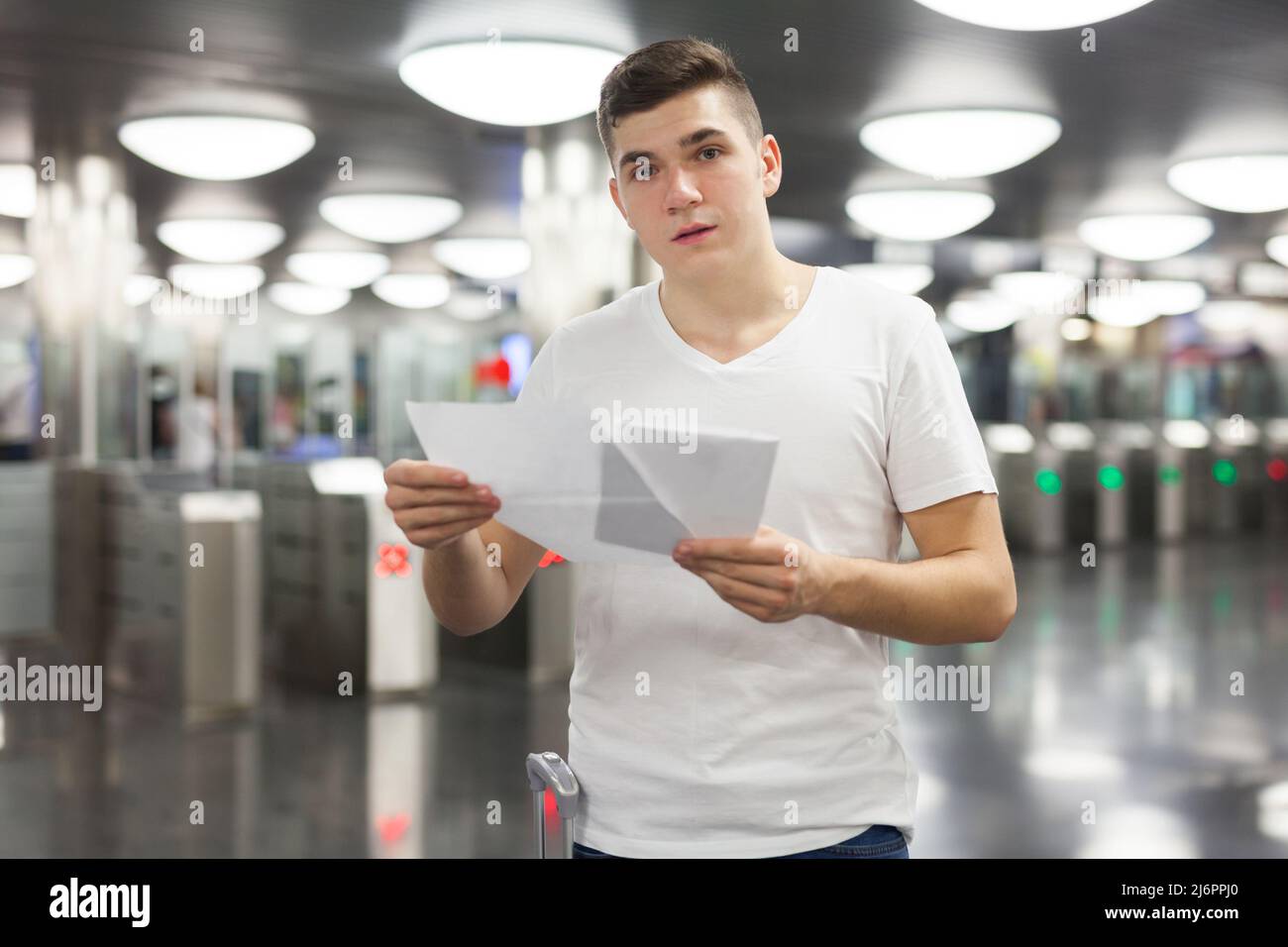 Passenger holding papers in subway Stock Photo - Alamy