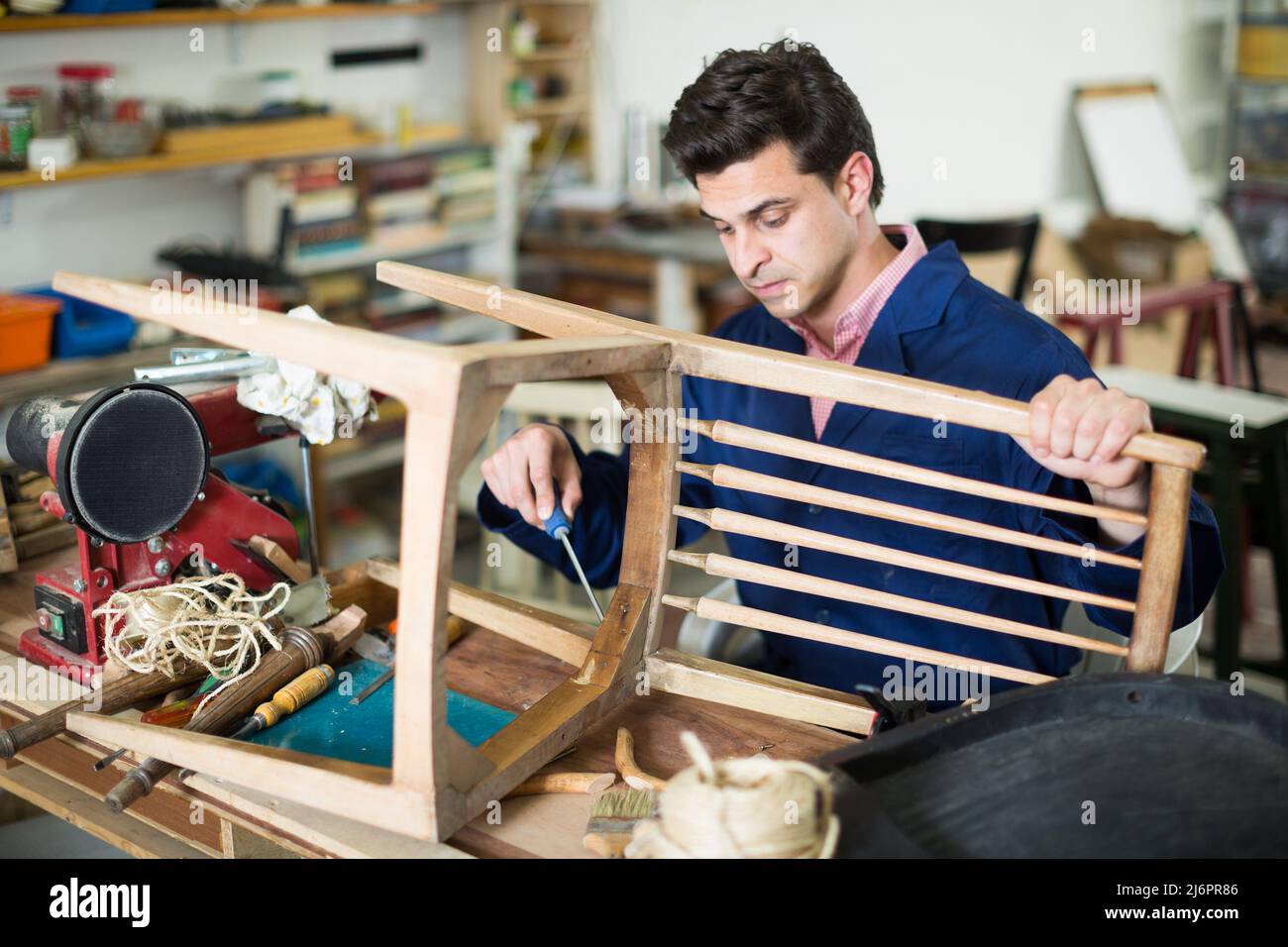 Man carpenter in furniture repair workshop Stock Photo - Alamy