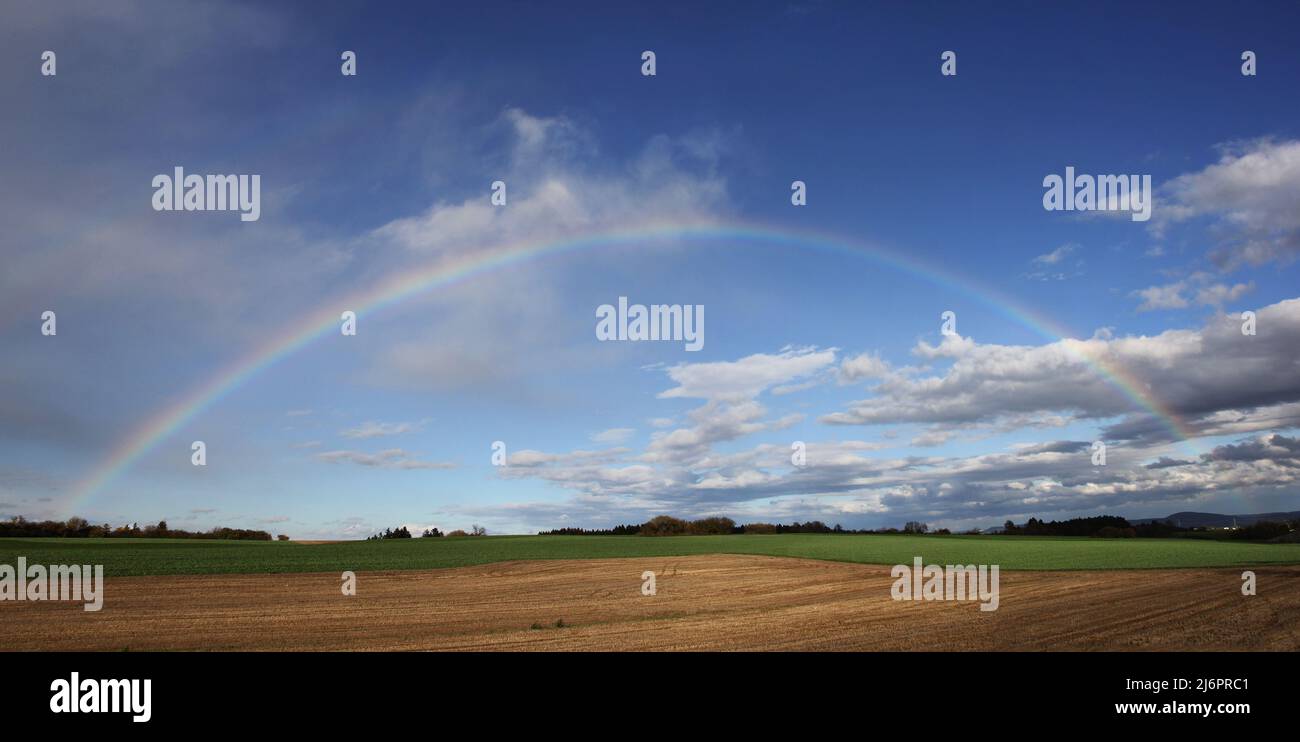 Rainbow appears over the field after rain Stock Photo - Alamy
