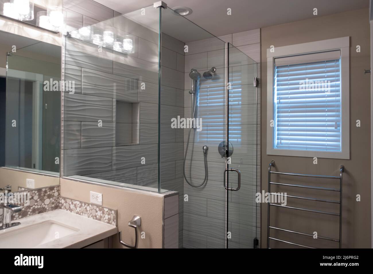 Angled view of a glass enclosed shower with a detachable showerhead ...
