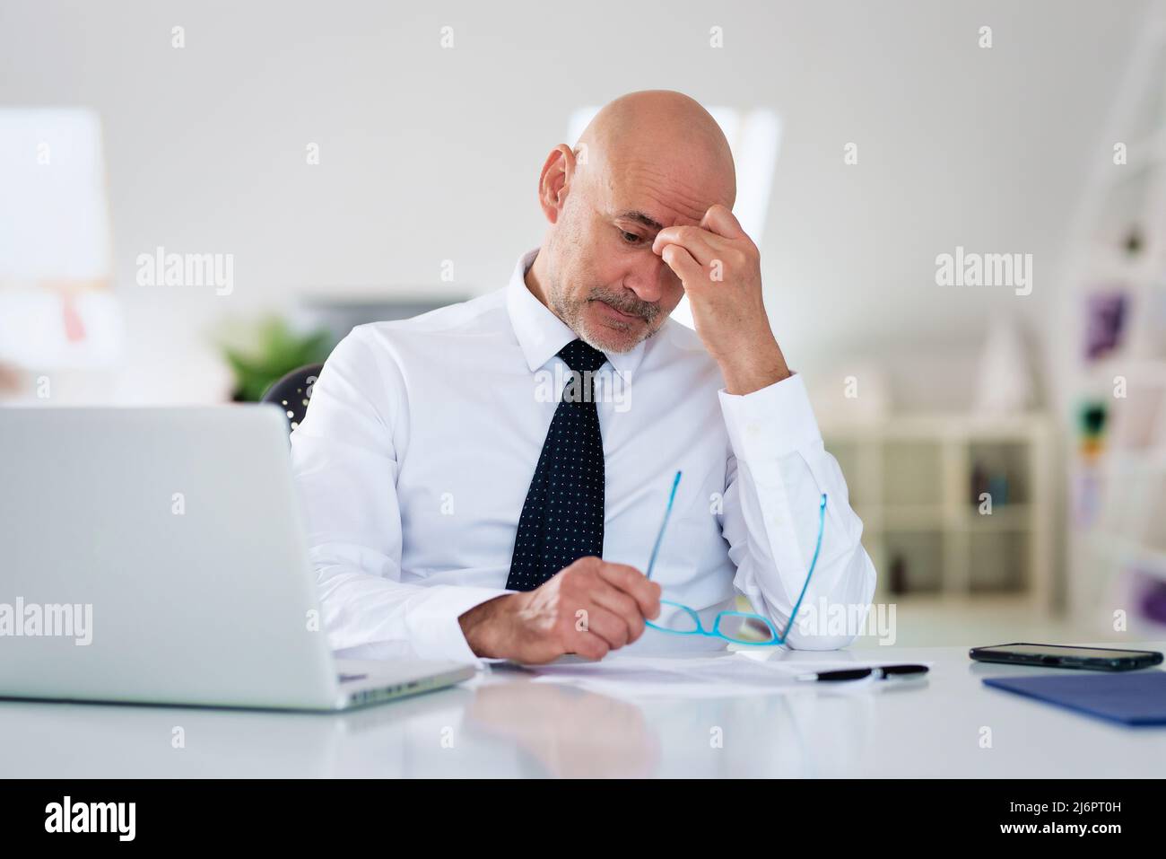 Confident businessman having a call and using laptop while sitting at ...