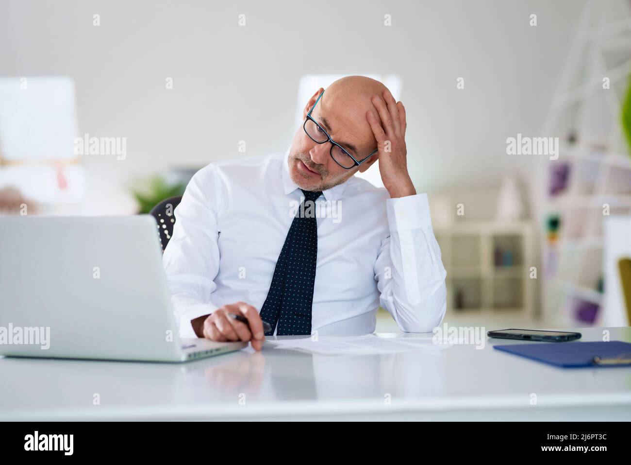 Confident businessman having a call and using laptop while sitting at ...