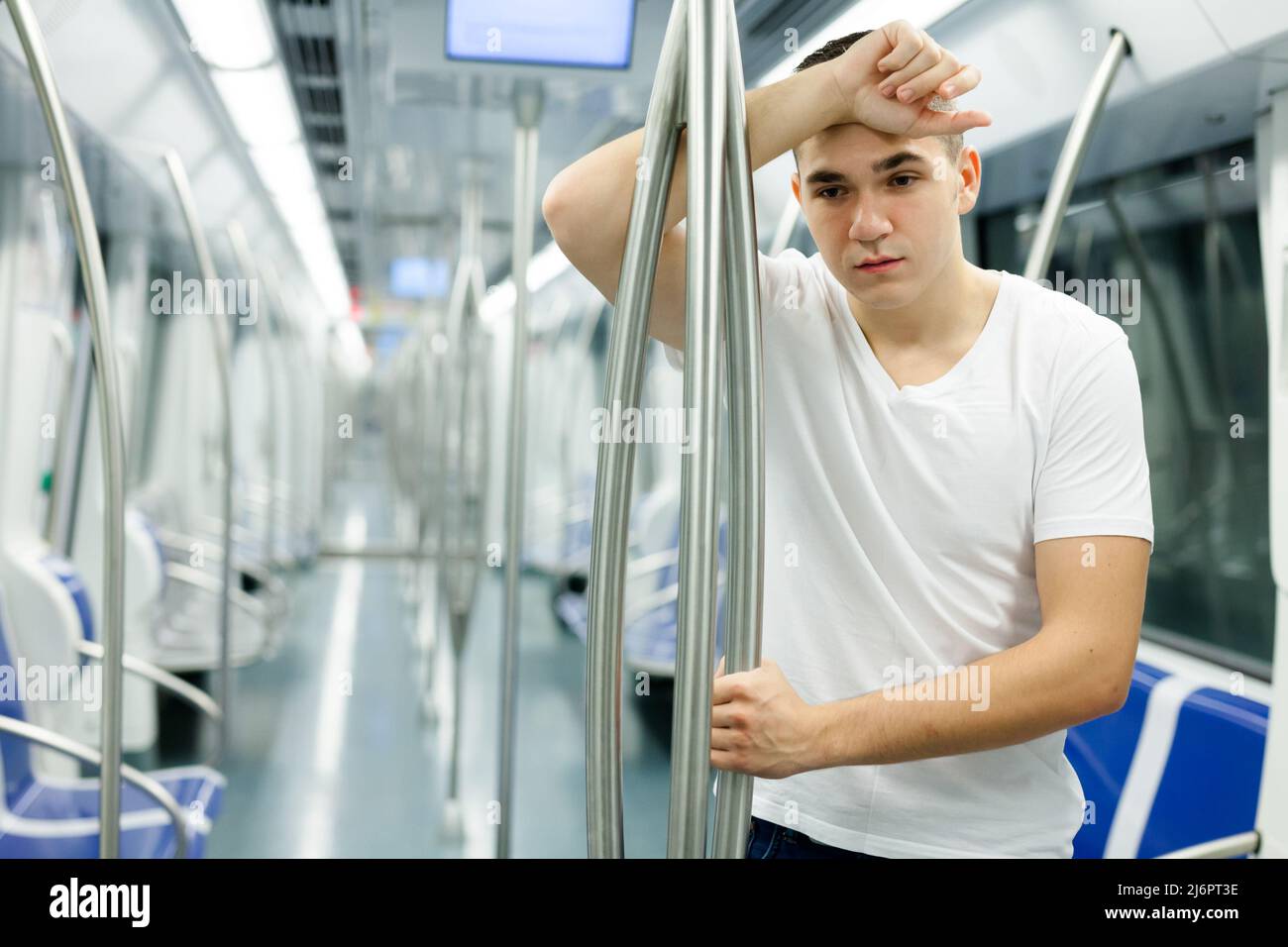 Tired man standing in underground carriage Stock Photo - Alamy