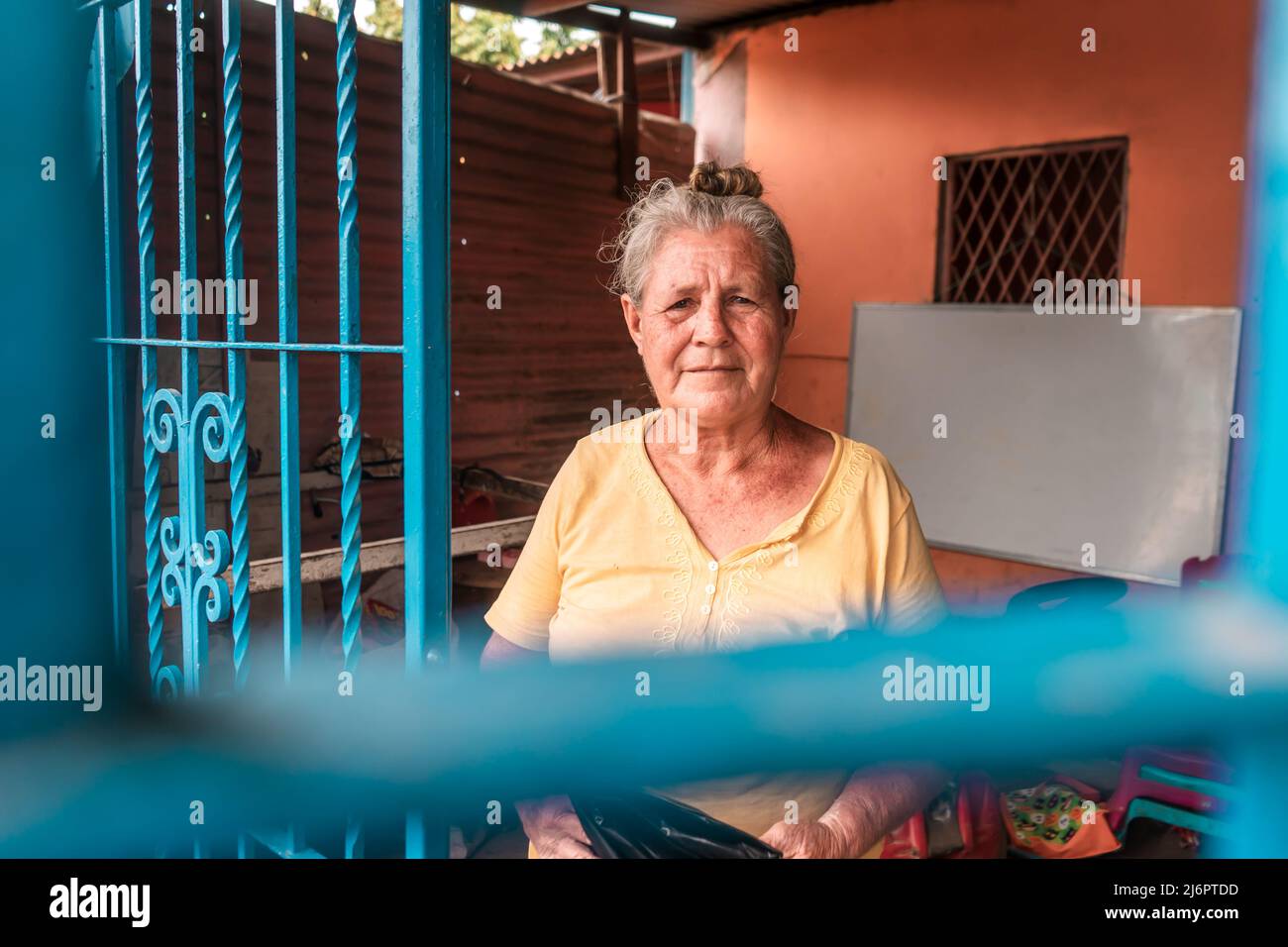 Elderly white latin woman with blue eyes at home looking at camera ...