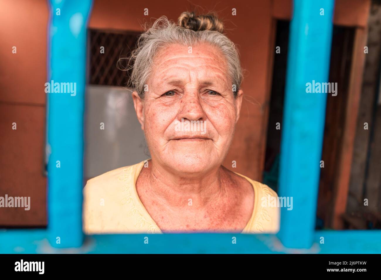 Elderly white latin woman with blue eyes at home looking at camera ...