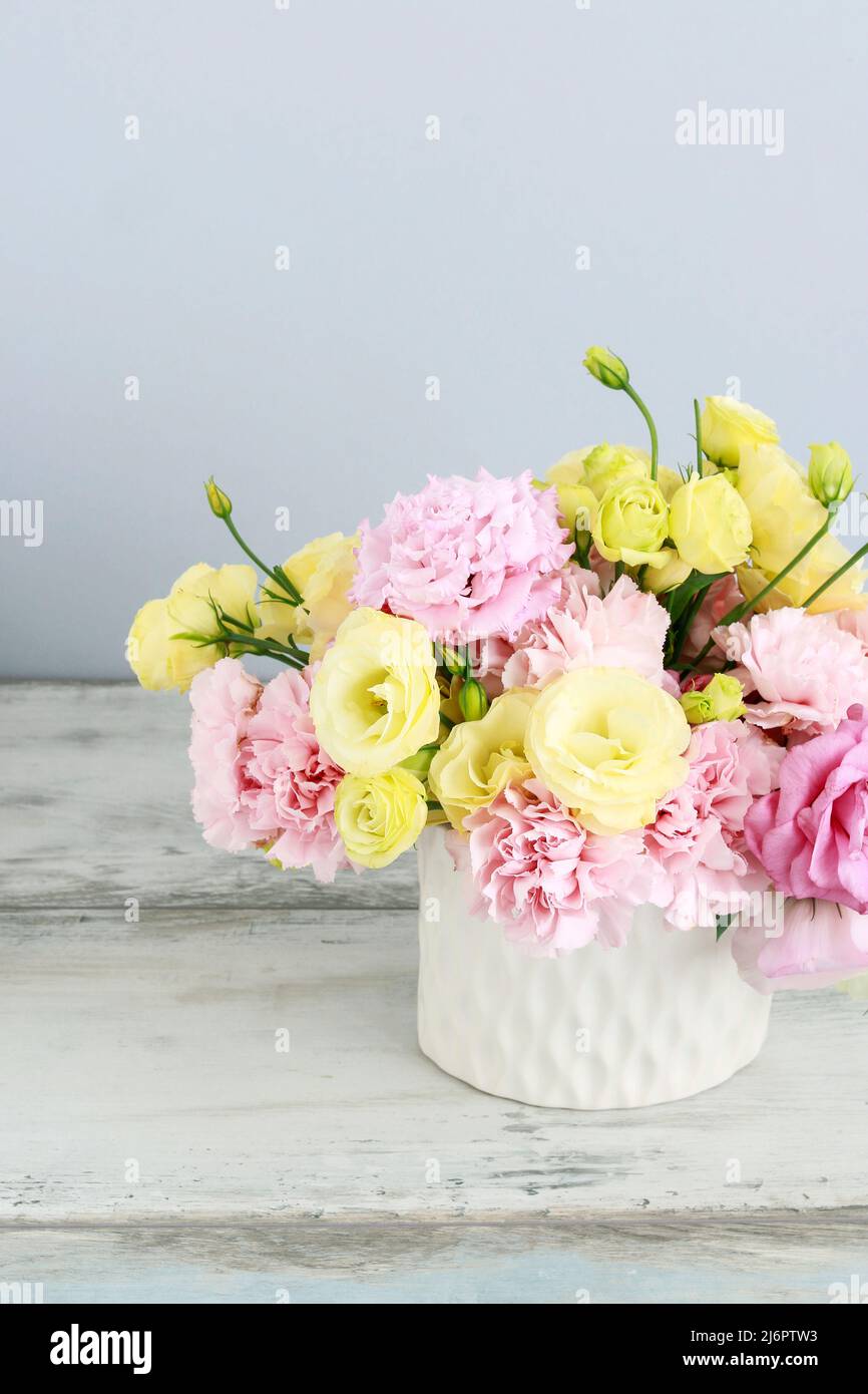 Floral arrangement with pink carnation and yellow eustoma flowers ...