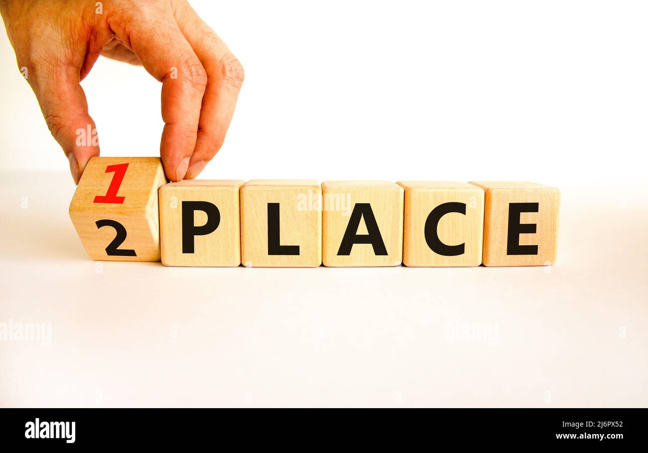 From 2 to 1 place symbol. Businessman turns wooden cubes and changes ...