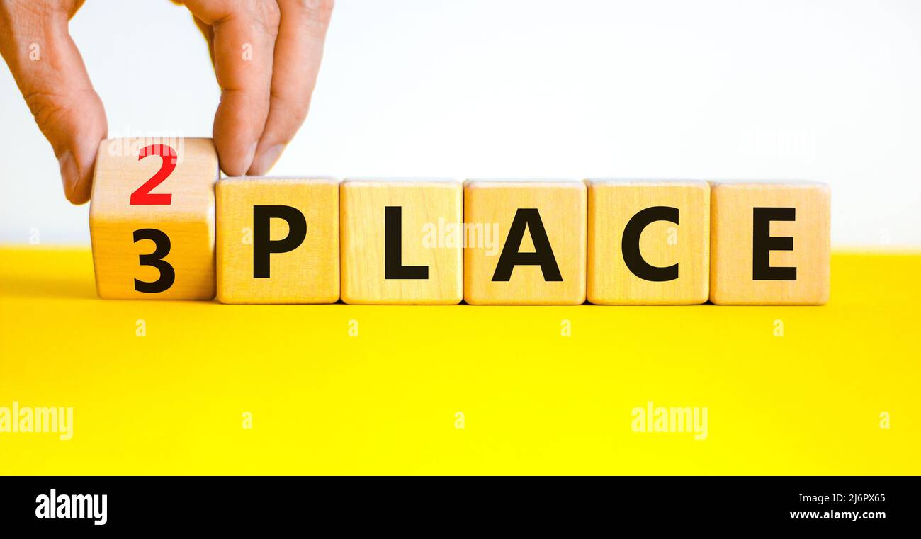From 3 to 2 place symbol. Businessman turns wooden cubes and changes ...