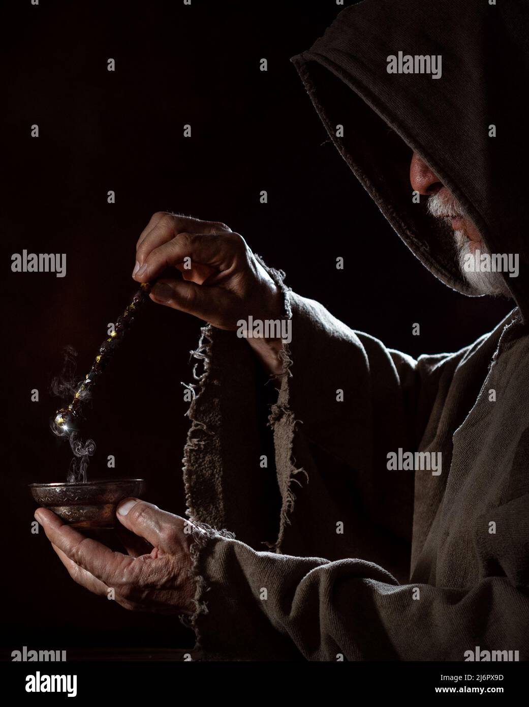 Medieval magician with magic wand mixing elixir Stock Photo - Alamy