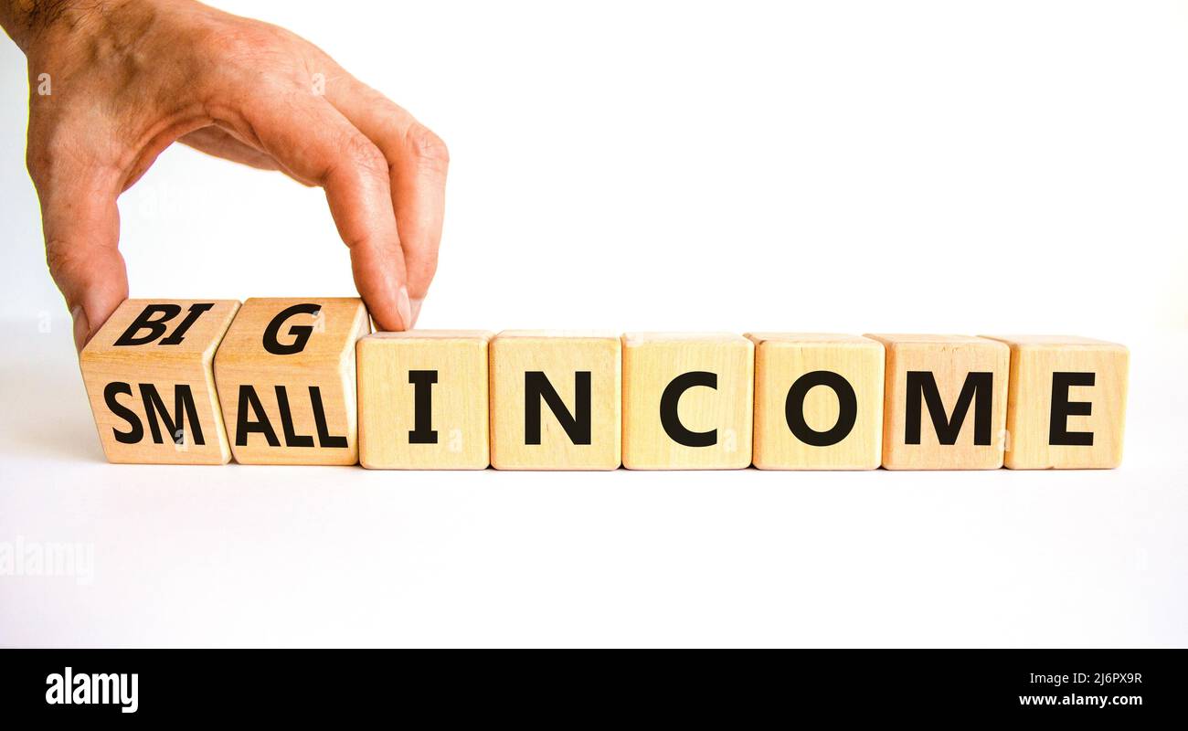 Big or small income symbol. Businessman turns wooden cubes and changes ...