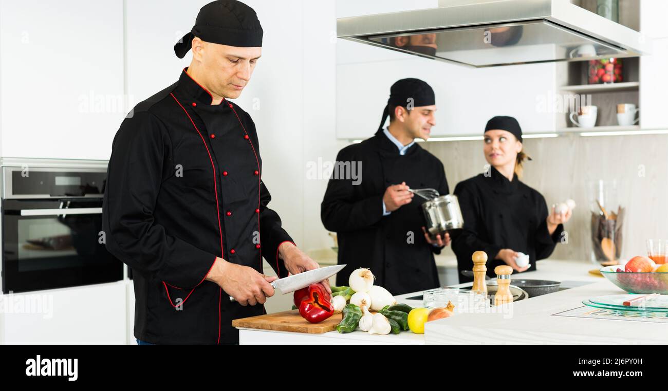 Male cook is making salad on his work place in the kitchen Stock Photo ...