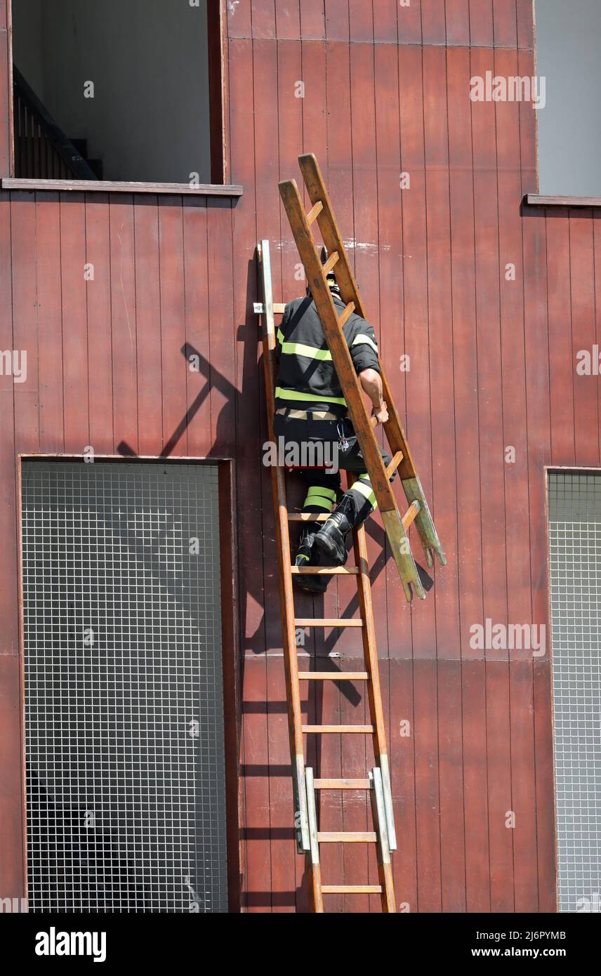 firefighter in action in the fire station with the long ladder ...