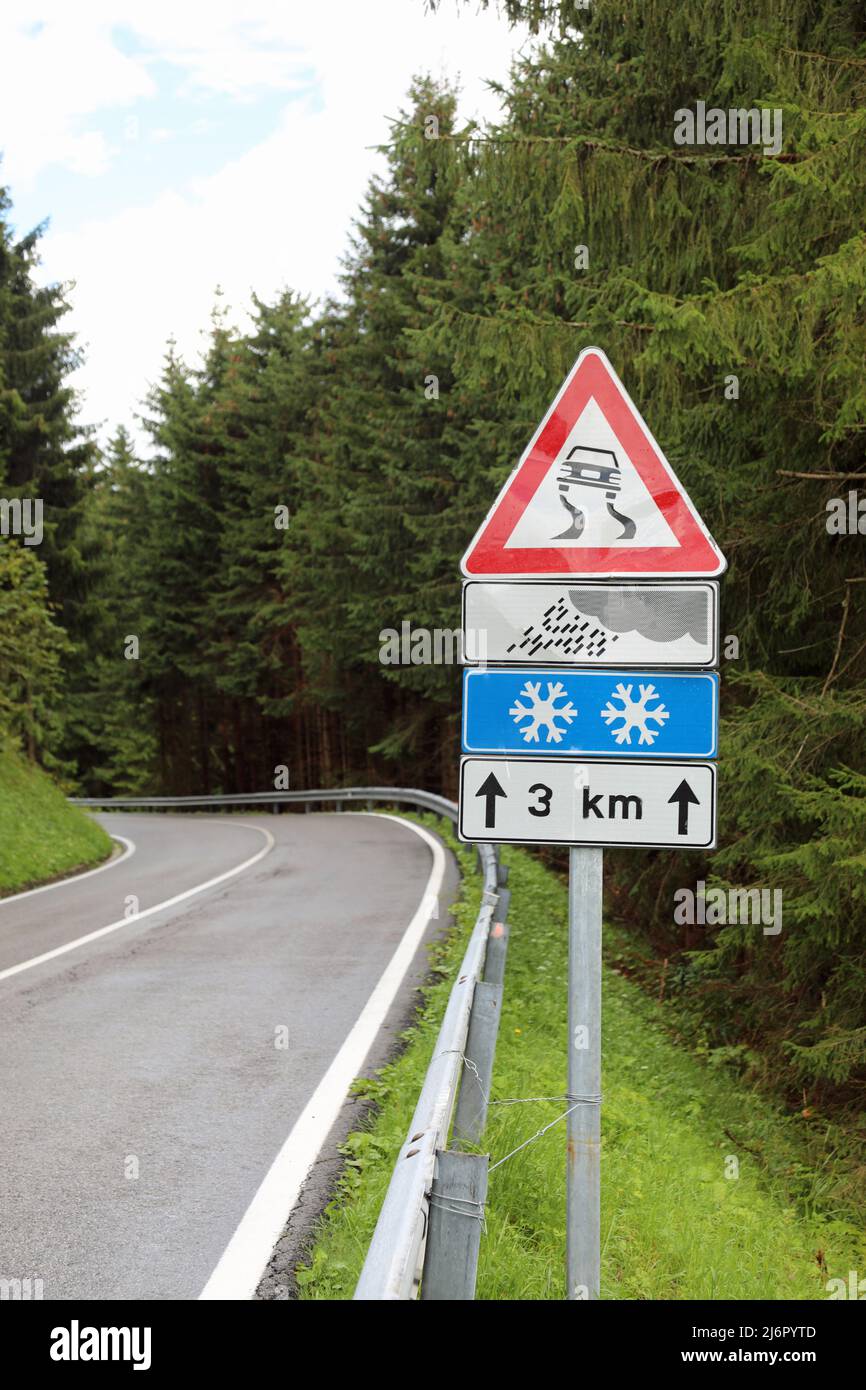 Road sign with the indication of CAUTION and slippery road in case of ...