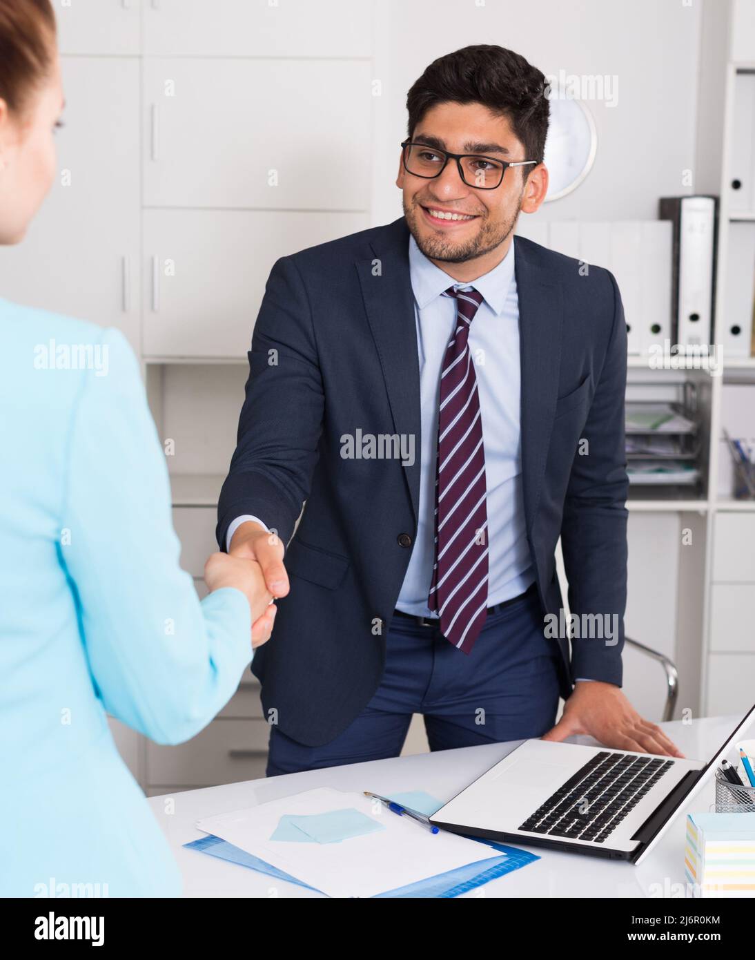Manager meeting client with handshake Stock Photo - Alamy