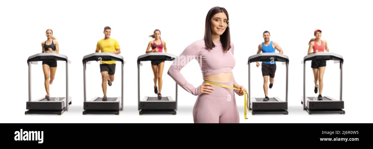 Young fit woman in sportswear measuring her waist and people running on ...
