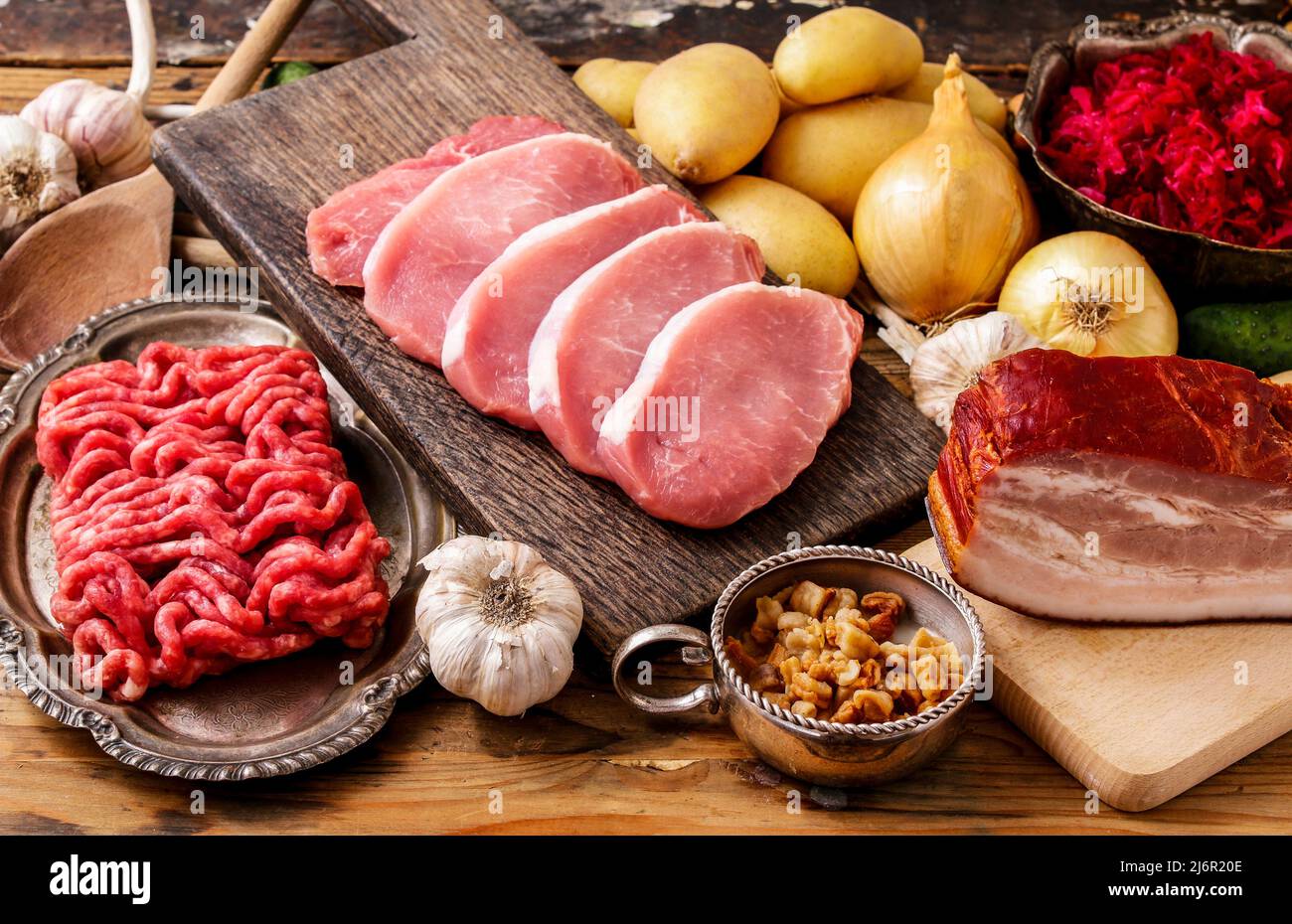 Different kinds of meat and vegetables on wooden table. Cooking time ...