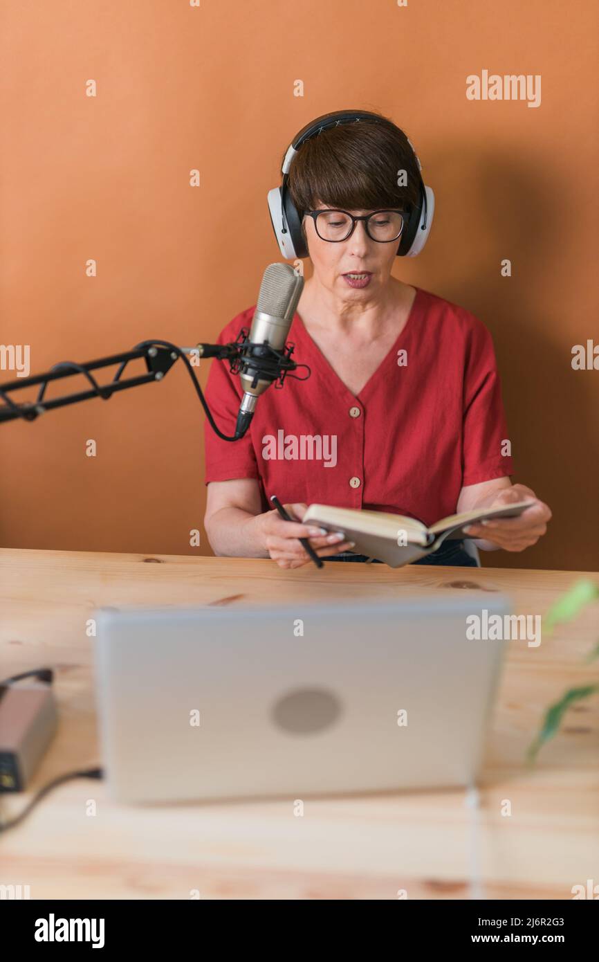 Middle-aged woman radio host making podcast recording for online show ...