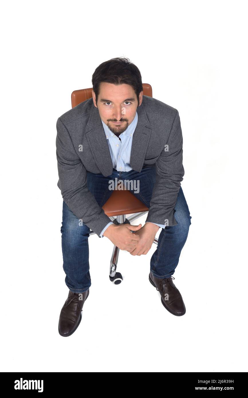 high angle view of a man sitting on chair looking at camera on white ...