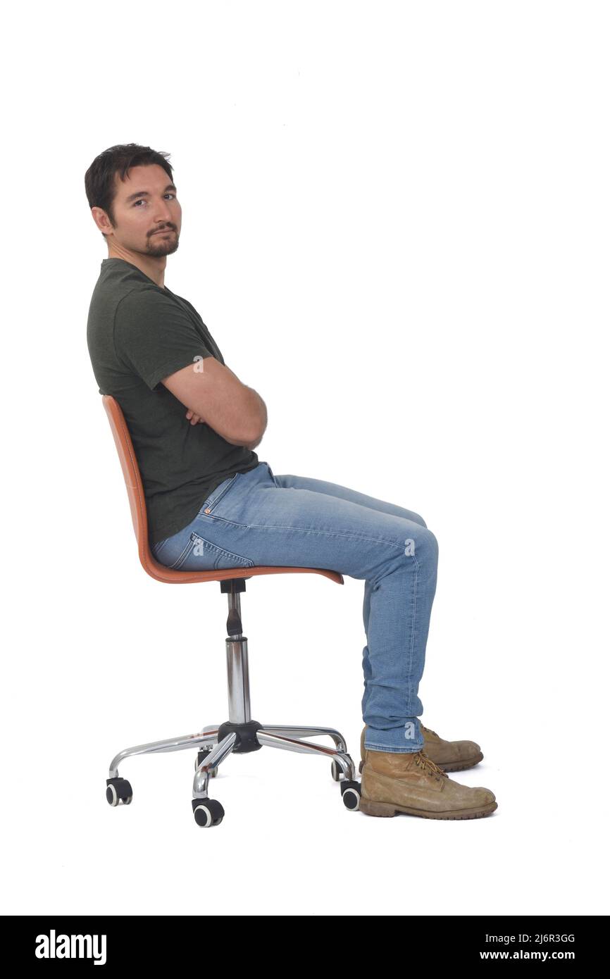 side view of a full portrait of man sitting on chair looking at camera ...