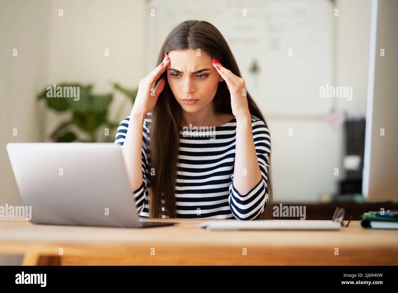 Female entrepreneur with headache sitting at desk. Businesswoman under ...