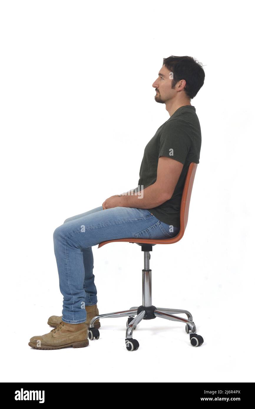 side view of a full portrait of man sitting on chair on whige ...