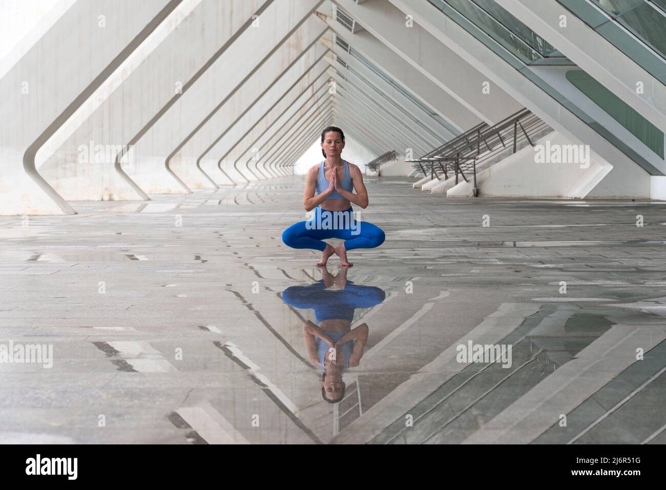 woman practices yoga asana Toe Balance pose outdoors against the ...