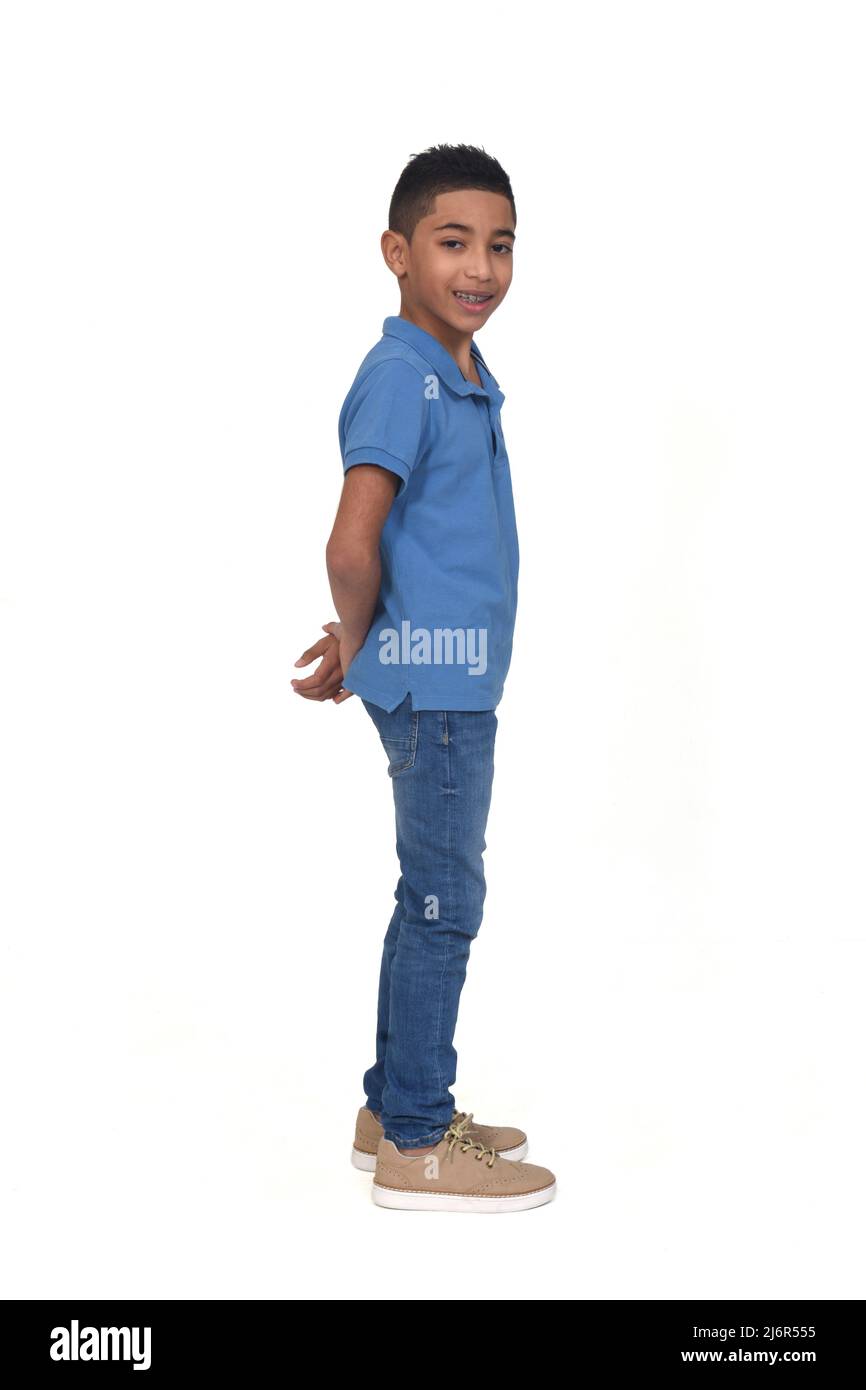 side view of boy arms on back and looking at camera on white background ...