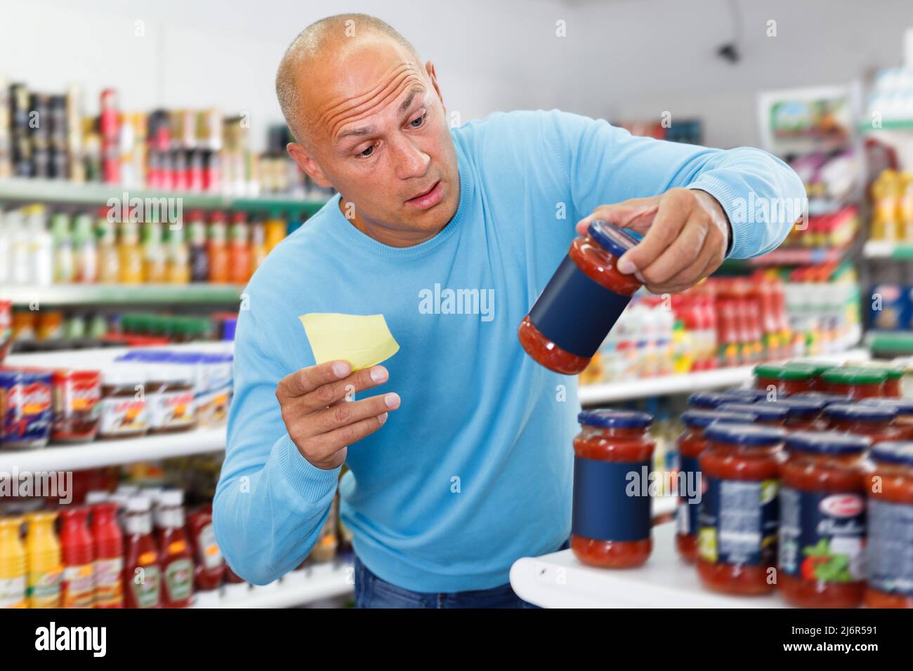 Portrait of interested man making purchases in the grocery store Stock ...