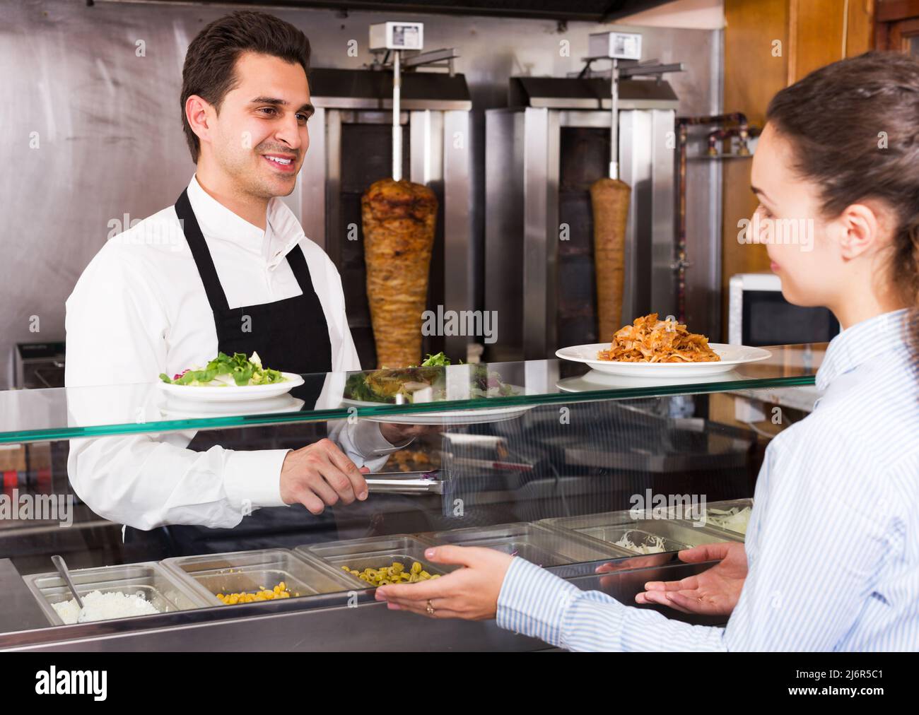 Male worker serving customer Stock Photo - Alamy