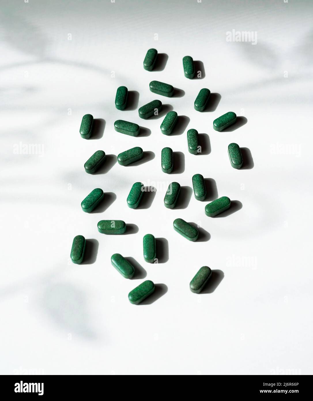 Pills of chlorella, spirulina, barley grass on white background with ...