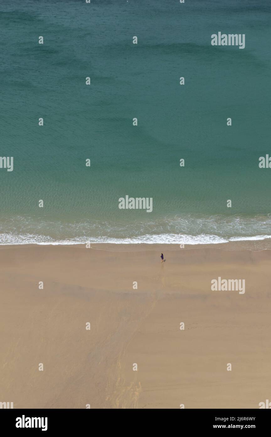 St. Agnes Bay, Cornwall - 2 July 202: Sandy beach with lone walkers and ...