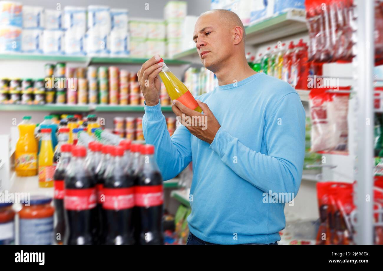 Portrait of calm man making purchases in the grocery store Stock Photo ...