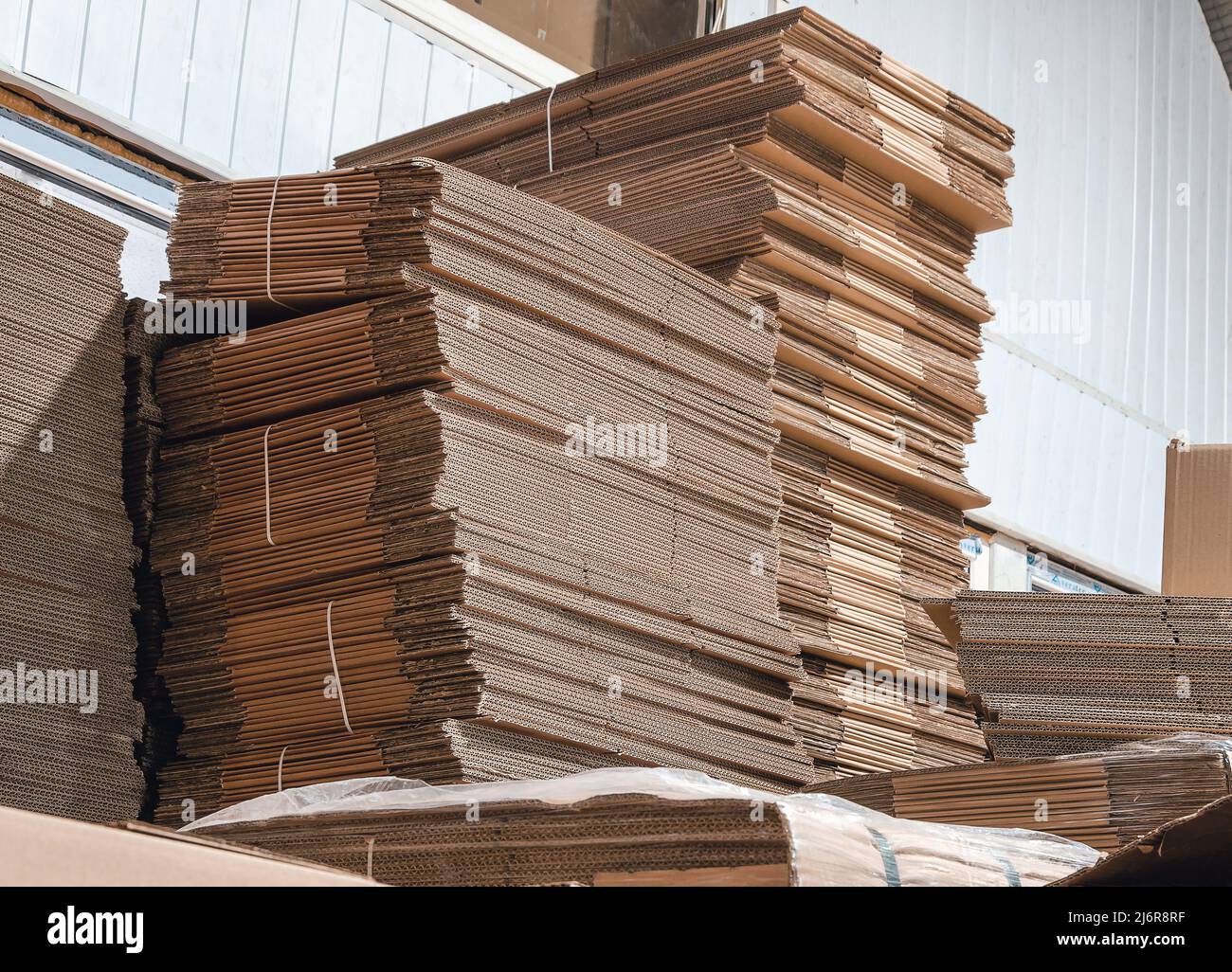 Folded cardboard boxes in warehouse. Stack of flat industrial folding ...