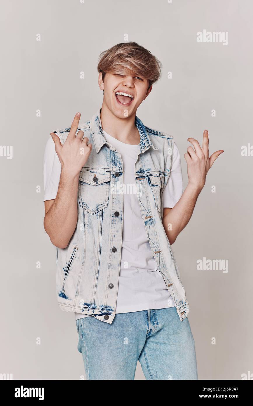 handsome man in denim showing victory gesture Stock Photo - Alamy