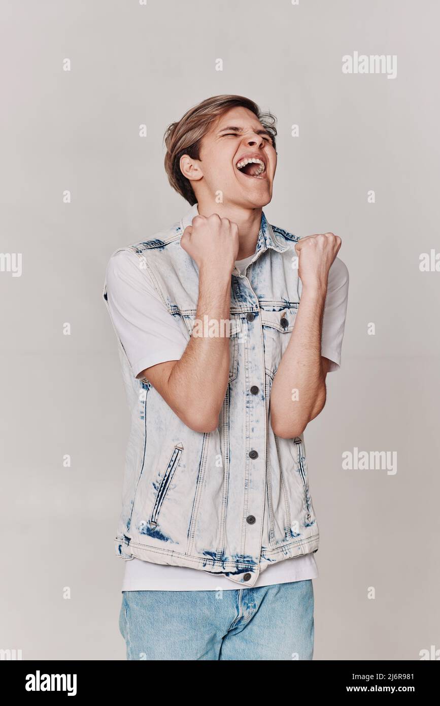 handsome man in denim showing victory gesture Stock Photo - Alamy