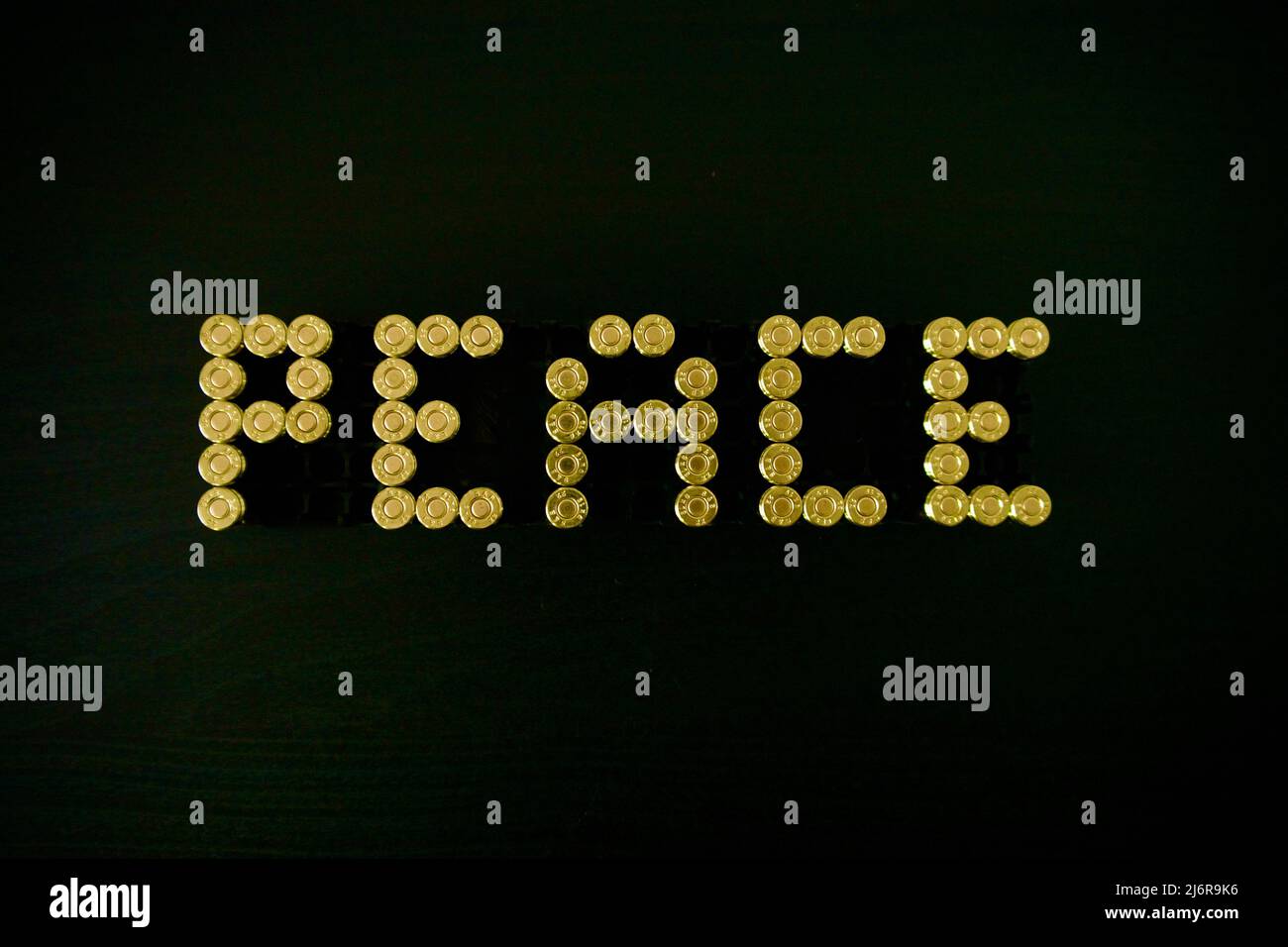 Word Peace made of 9 mm ammo on black wooden desk, golden bullets Stock ...