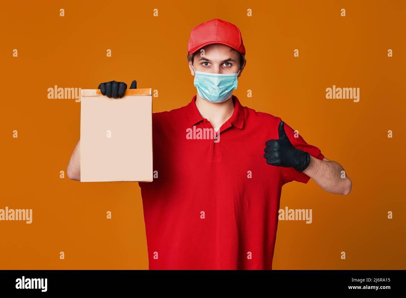 Delivery man employee in red cap face mask, empty cardboard box Stock ...